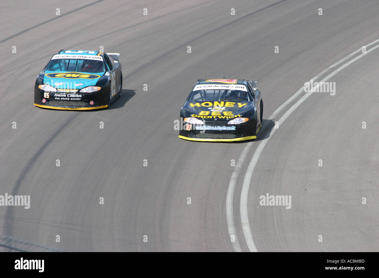 V8 Nascar type stock cars racing on a banked oval circuit Stock Photo ...