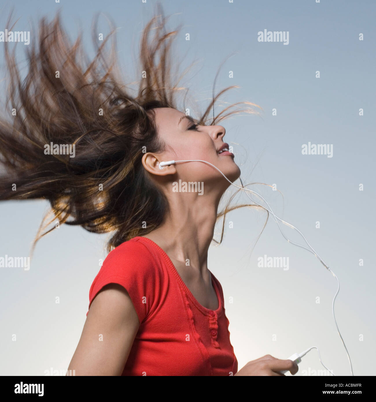 Side profile of a young woman listening to an MP3 player Stock Photo ...