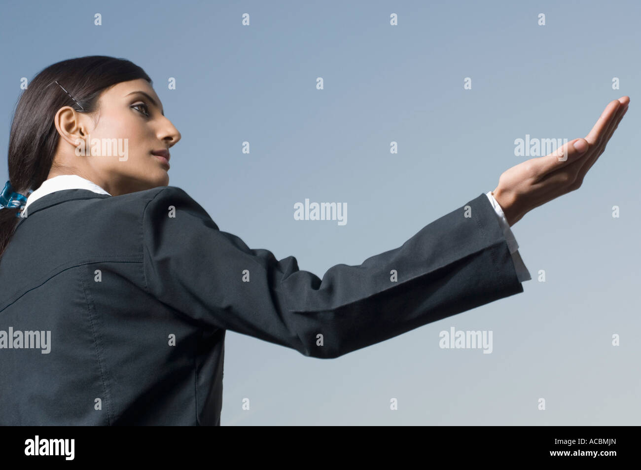 Side profile of a businesswoman holding her palm out Stock Photo - Alamy