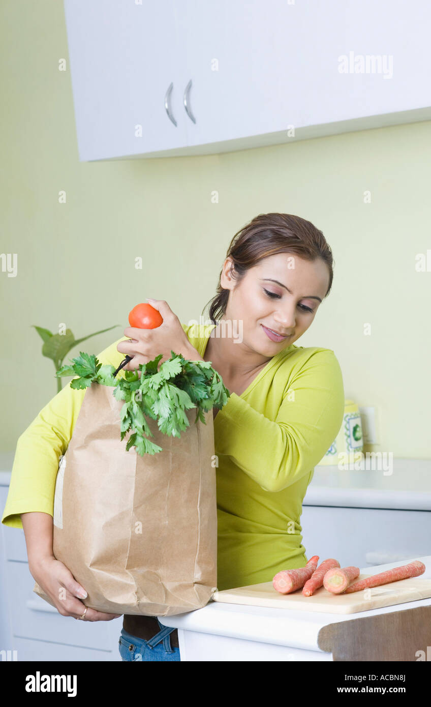 Young woman carrying a bag of vegetables and smiling Stock Photo - Alamy