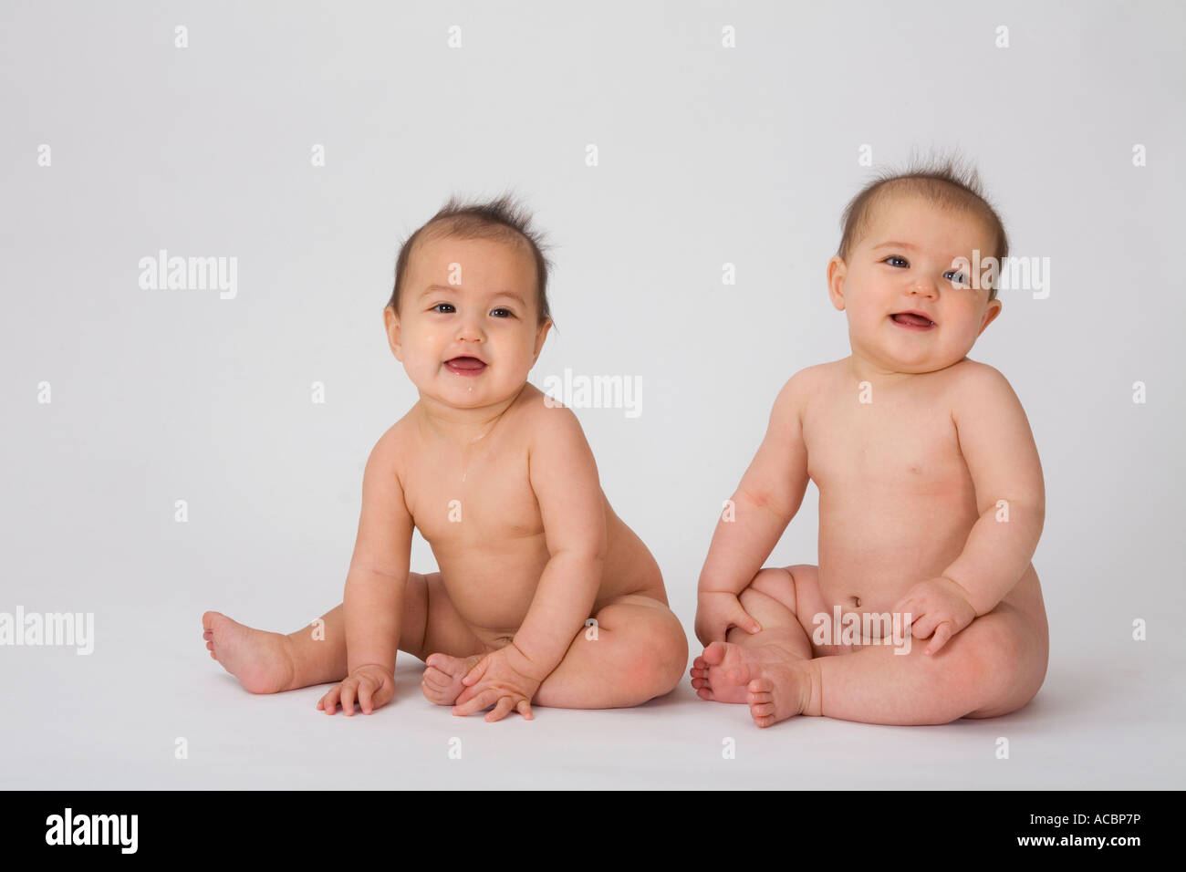 Portrait of twin babies sitting together Stock Photo - Alamy