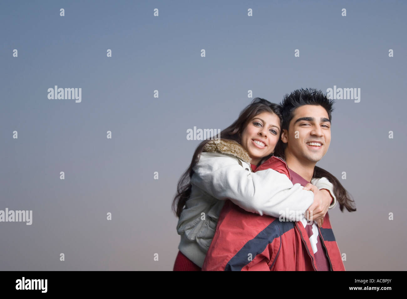 Side profile of a young woman riding piggyback on a young man Stock ...