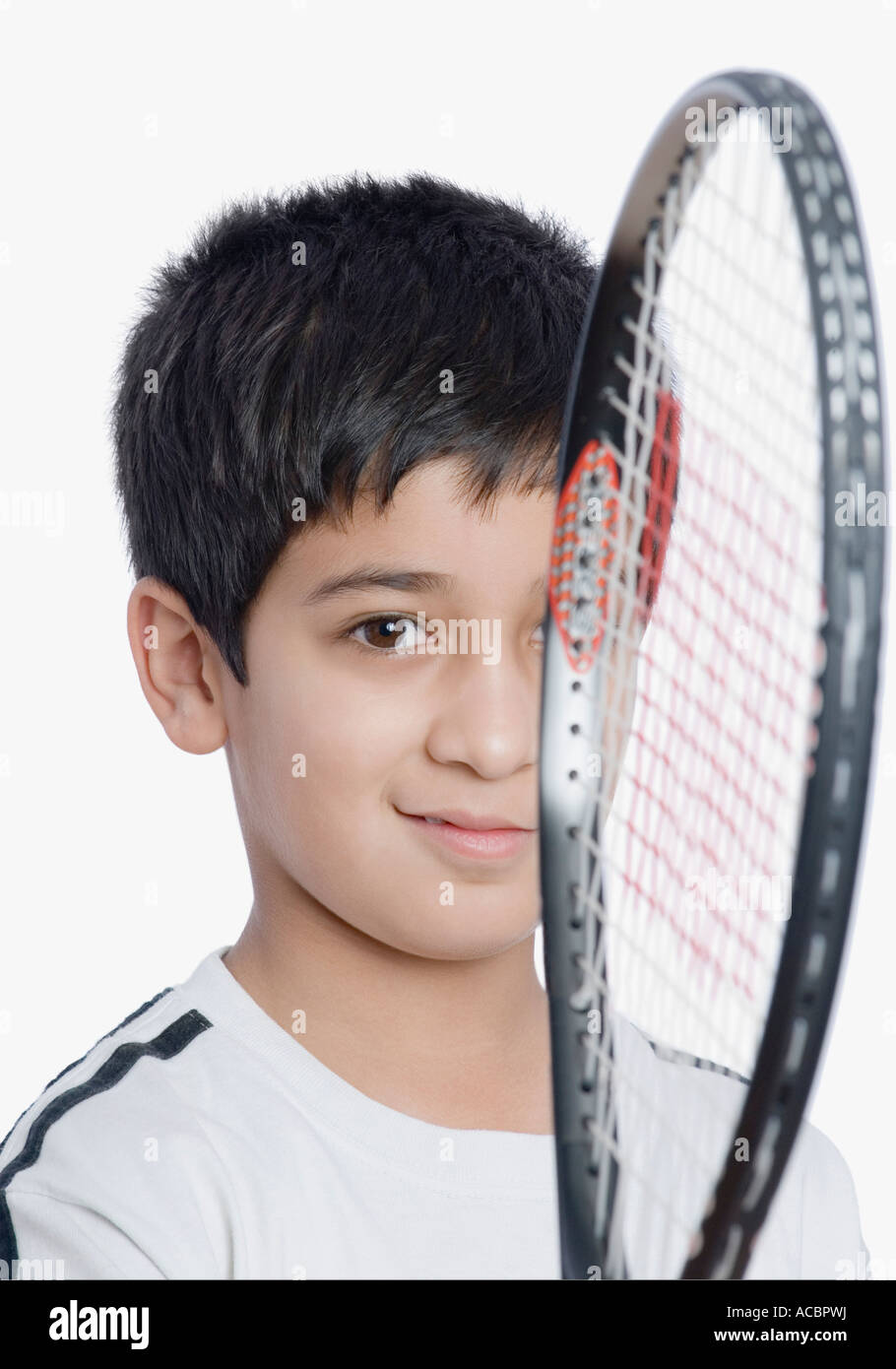 Portrait of a boy holding a tennis racket in front of his face Stock ...