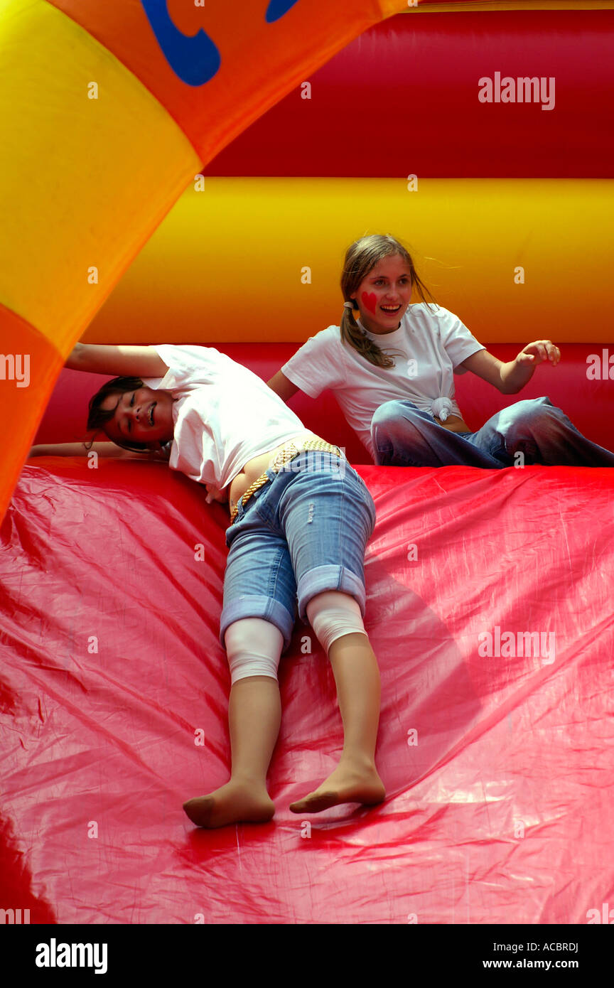Girls sliding on inflatable red slide Stock Photo - Alamy