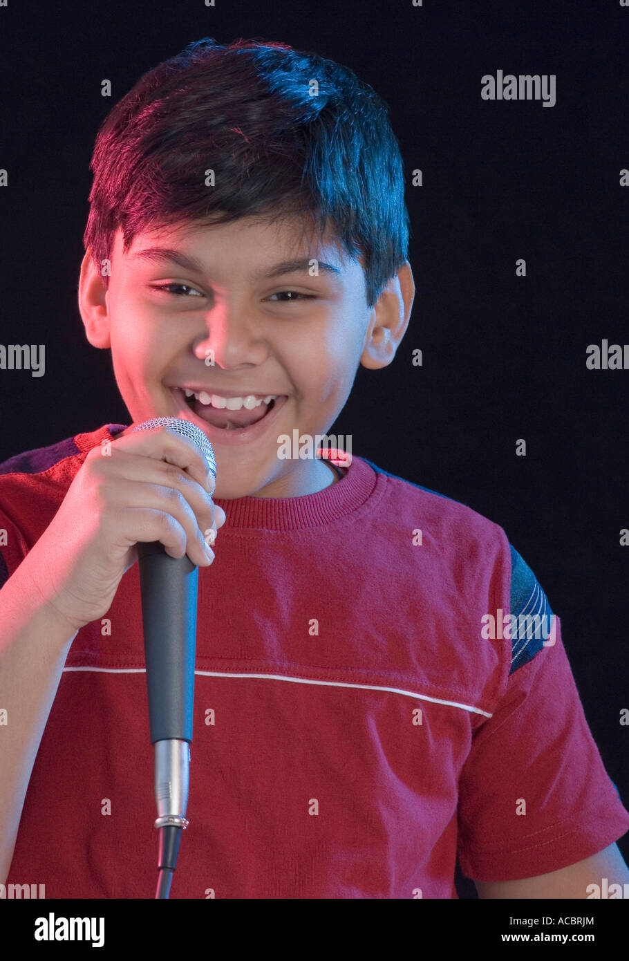 Portrait of a boy singing and holding a microphone Stock Photo - Alamy