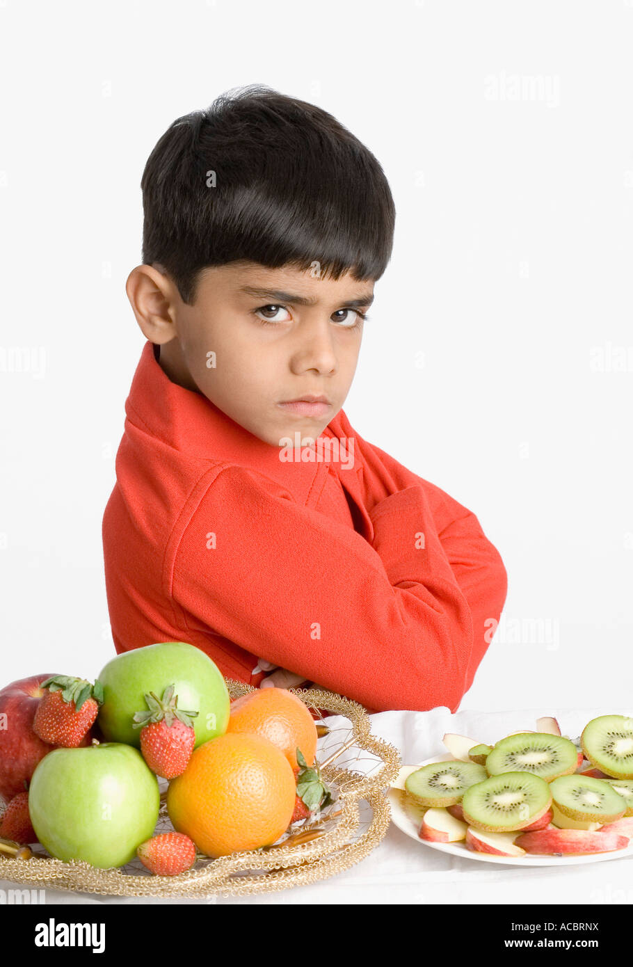 Portrait of a boy looking angry at a breakfast table Stock Photo - Alamy