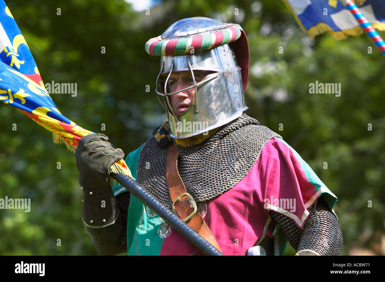 Man dressed as a Knight and carrying a Coat of Arms at an historical re ...