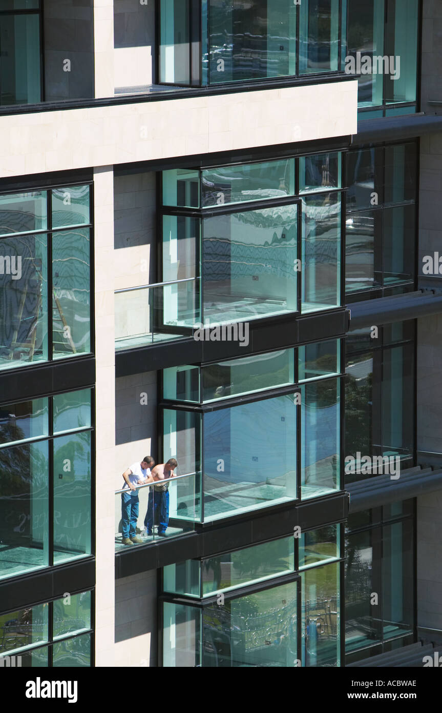 Two men looking down from a balcony on a multi story building Stock ...