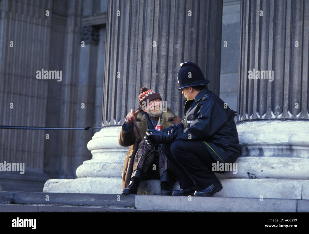 Homeless man talking with policeman Stock Photo - Alamy