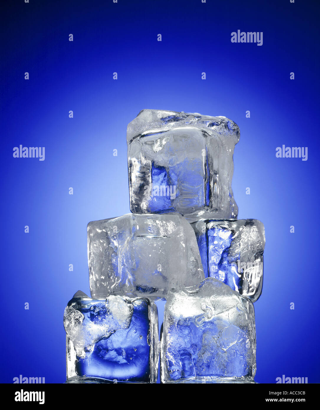 Stack of five ice cubes against blue spotlit background Stock Photo - Alamy