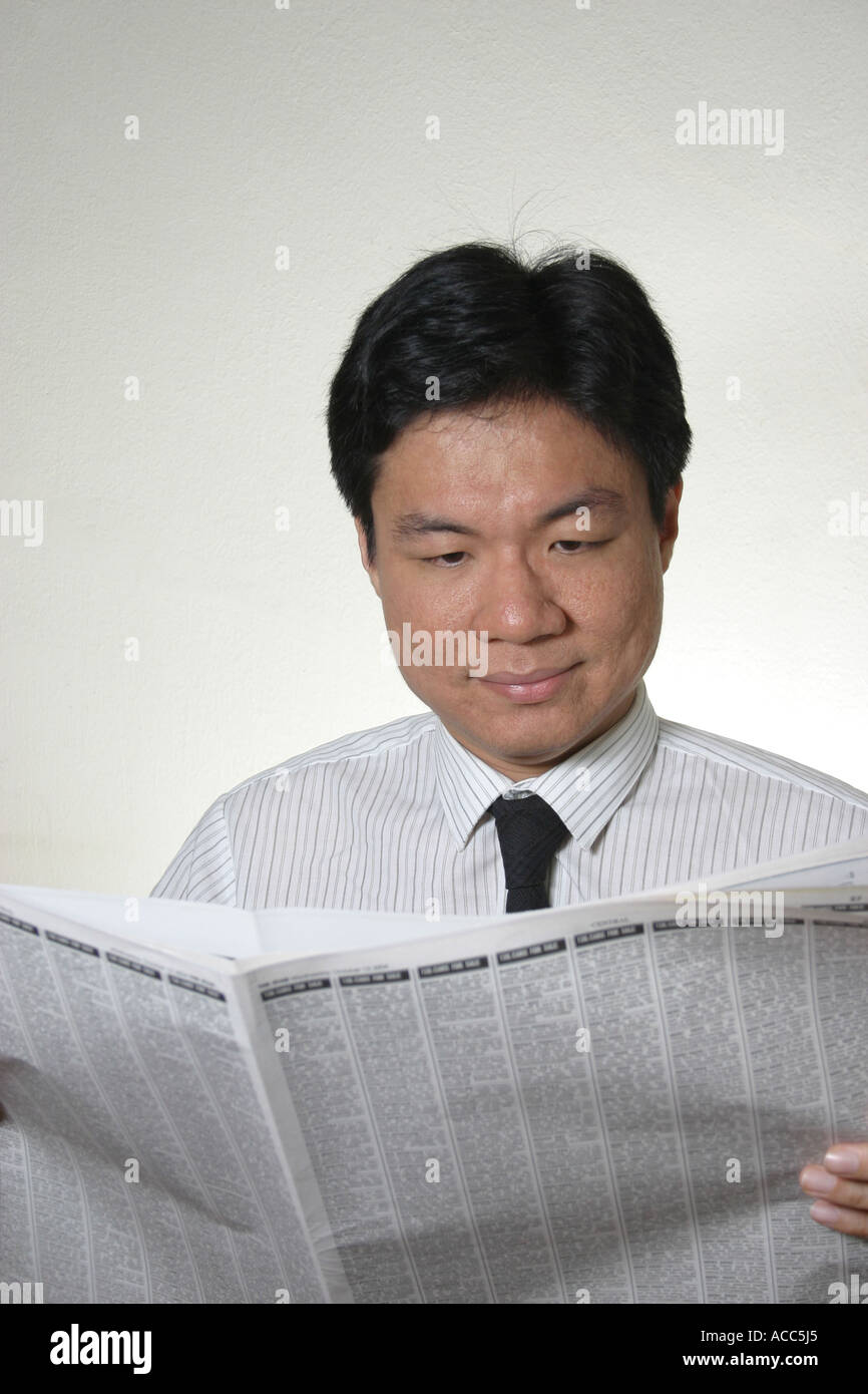 young man of Chinese descent reading a newspaper Stock Photo - Alamy
