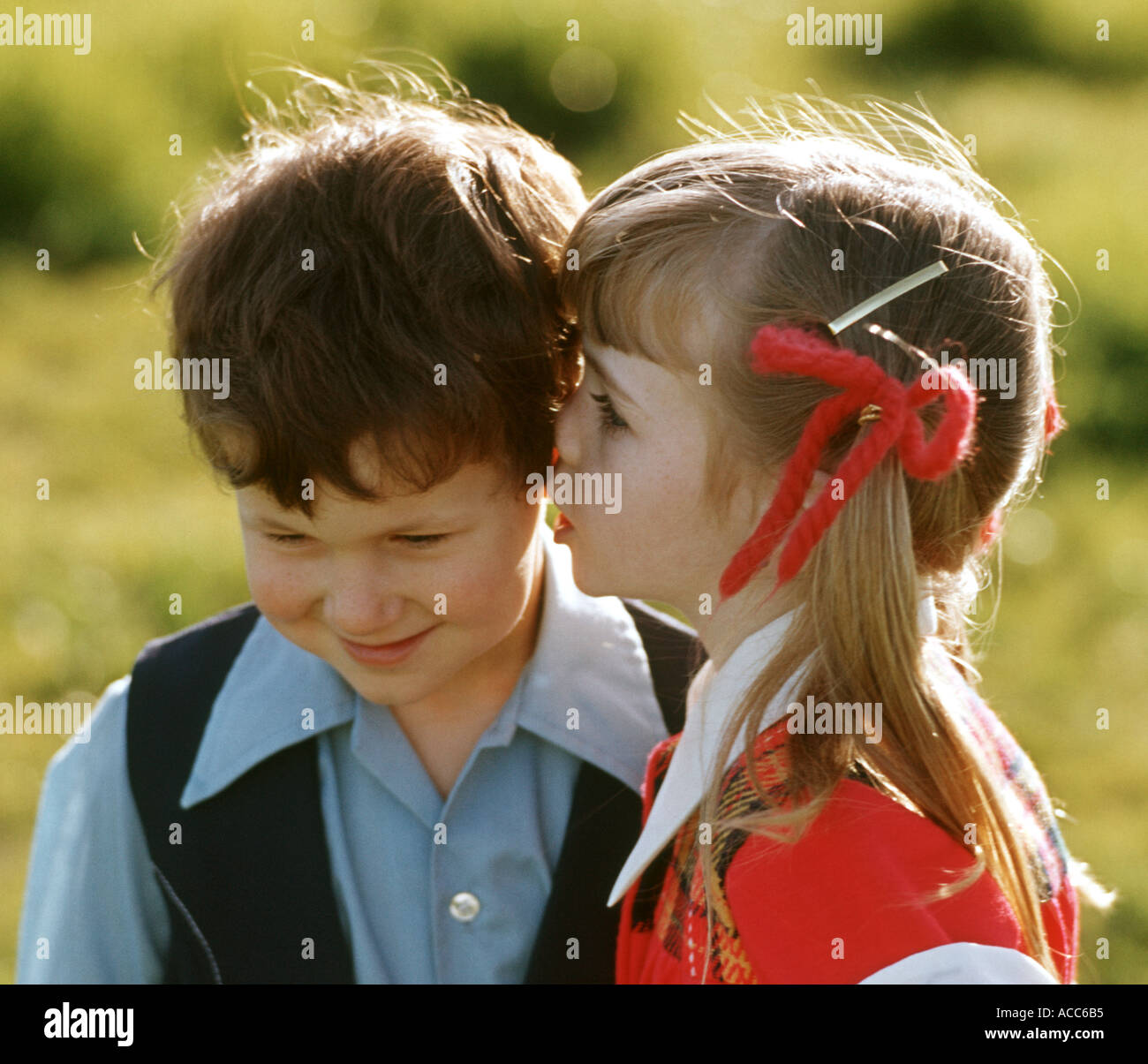 little girl whispering a secret to little boy Stock Photo - Alamy
