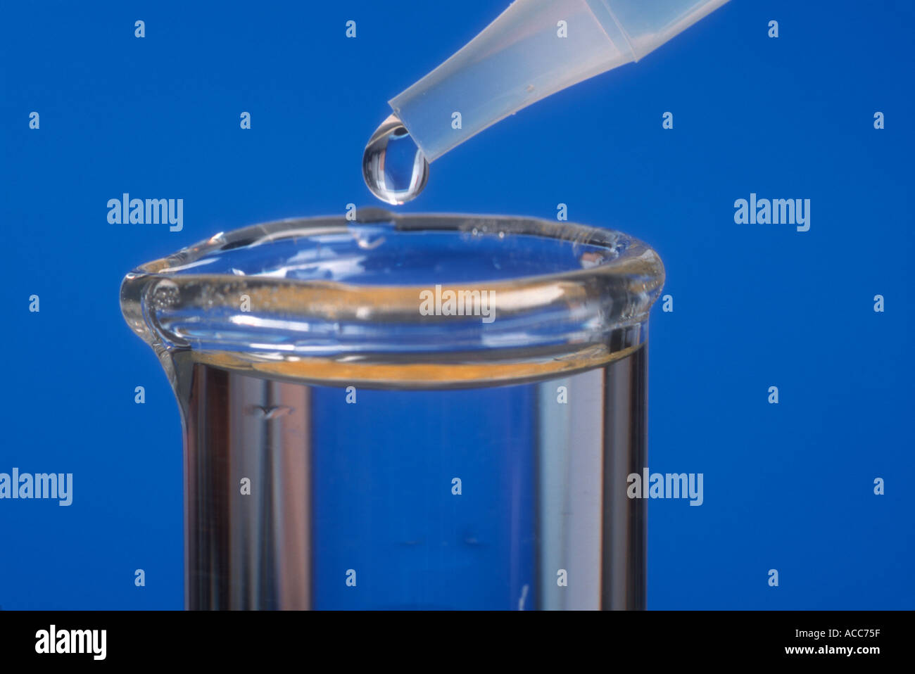 eye dropper dripping liquid into beaker Stock Photo - Alamy