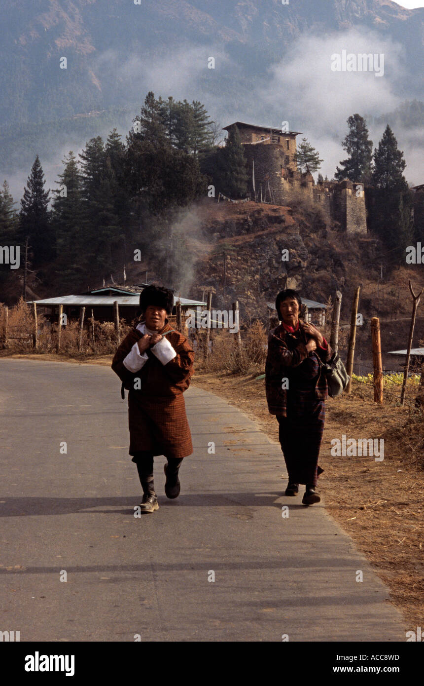 Women walk along a paved road in Bhutan Stock Photo - Alamy