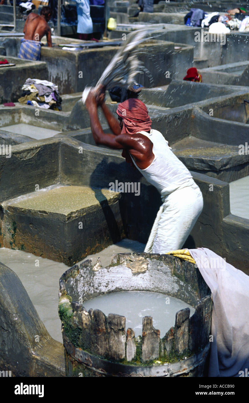 An Indian man washing families clothes at a public laundrette in Mumbai ...