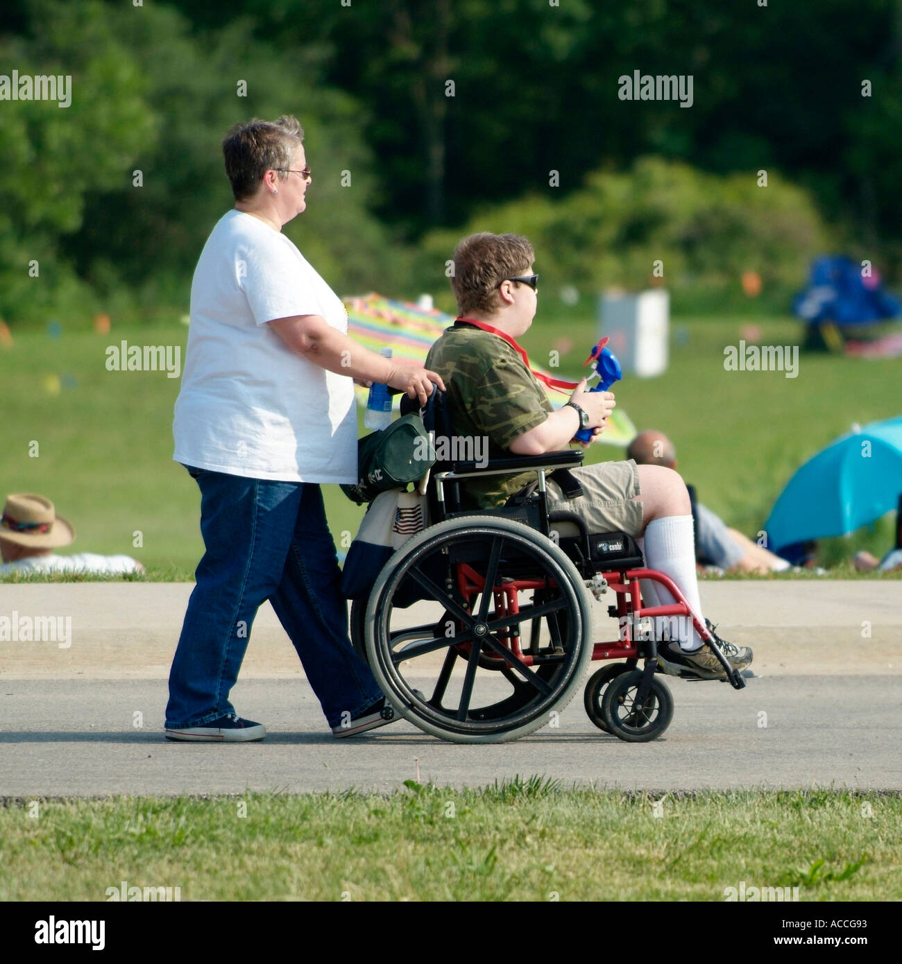 Handicapped adults ride in a battery powered wheelchair while attending ...