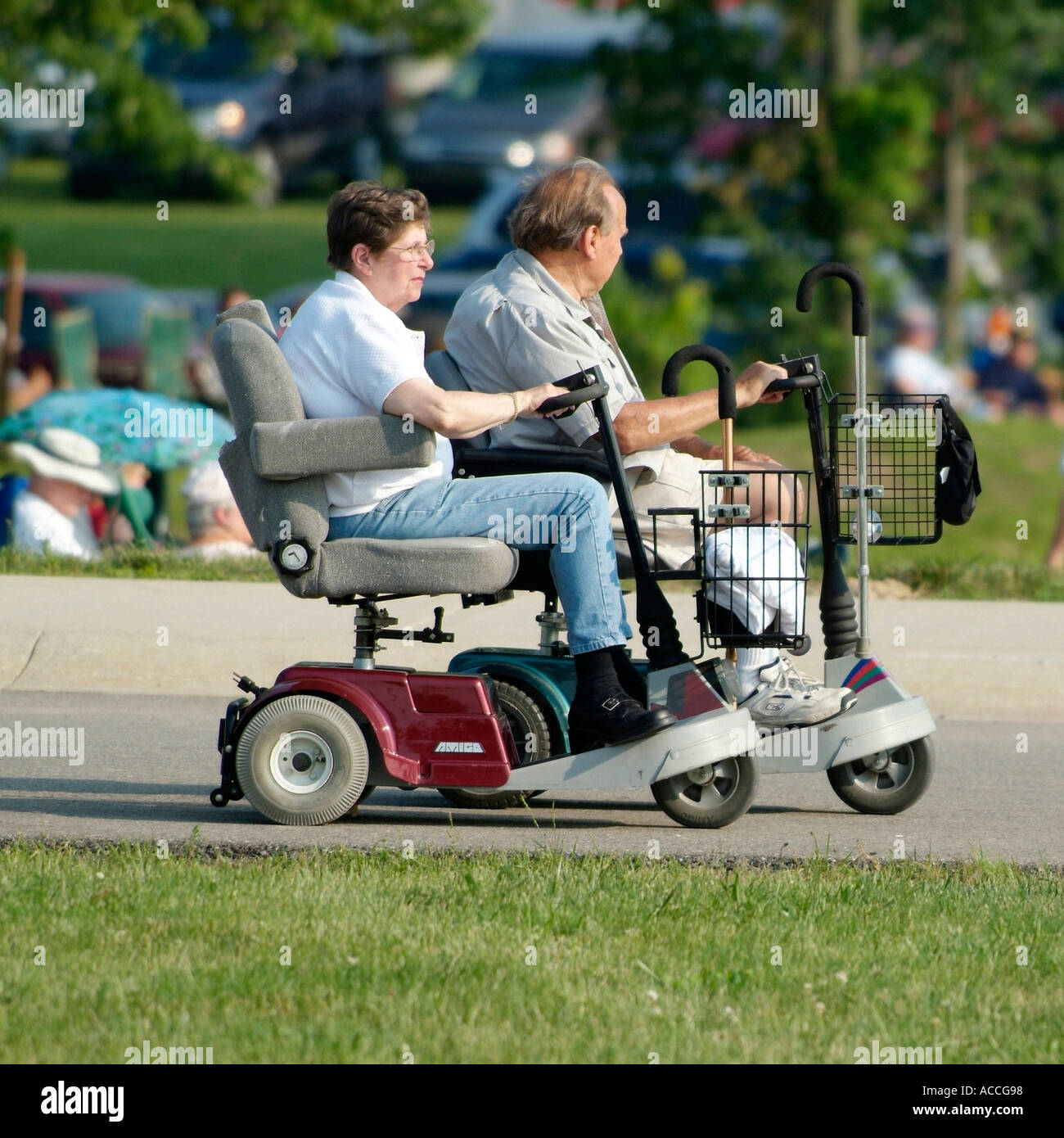 Handicapped adults ride in a battery powered wheelchair while attending ...