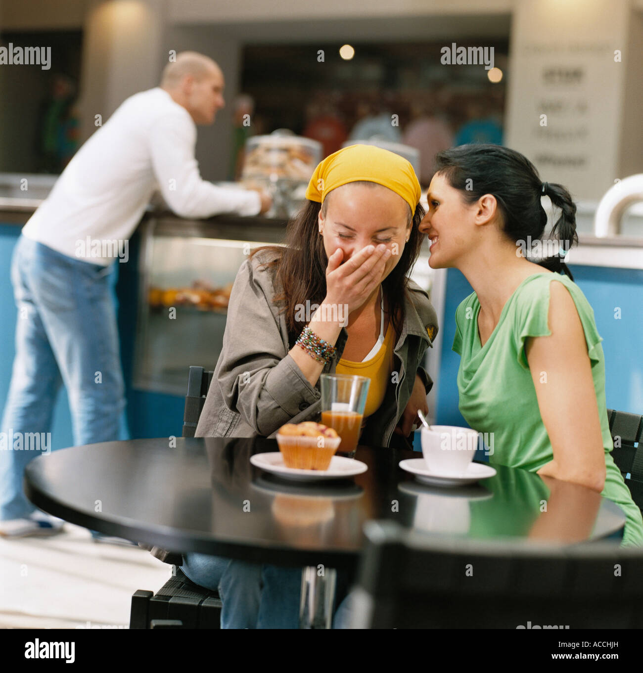 Two women laughing in a café Stock Photo - Alamy