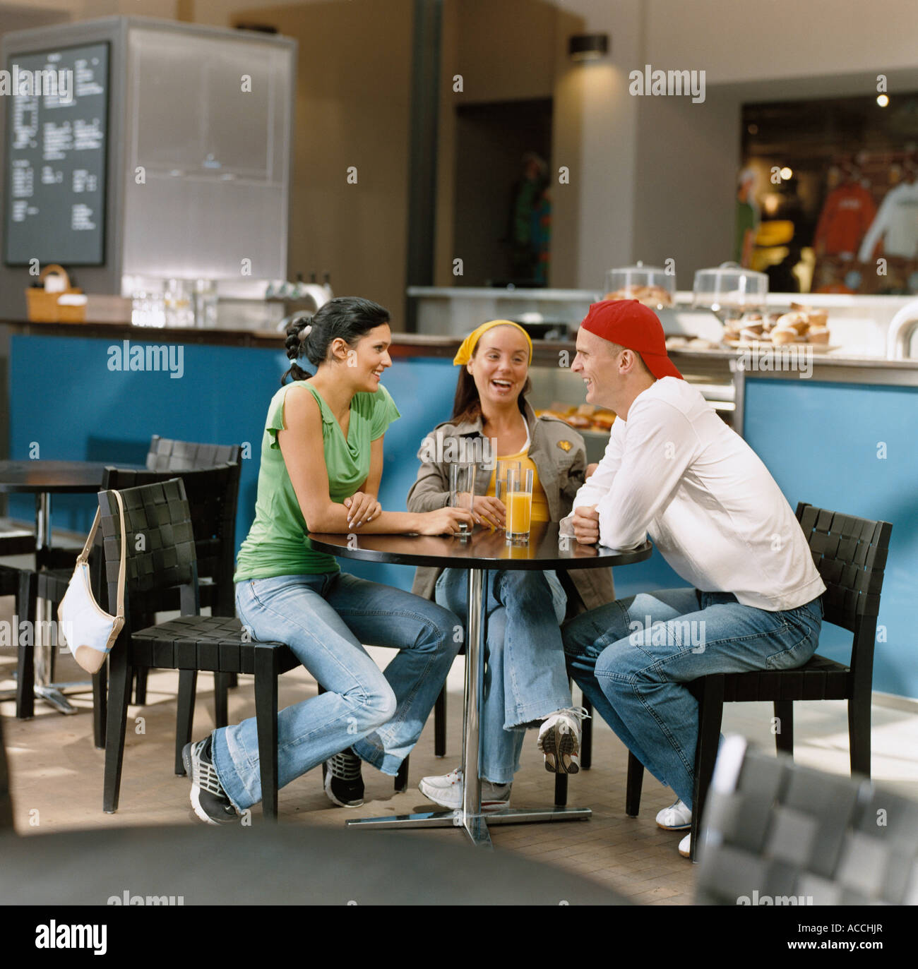 Three people in a cafe Stock Photo - Alamy
