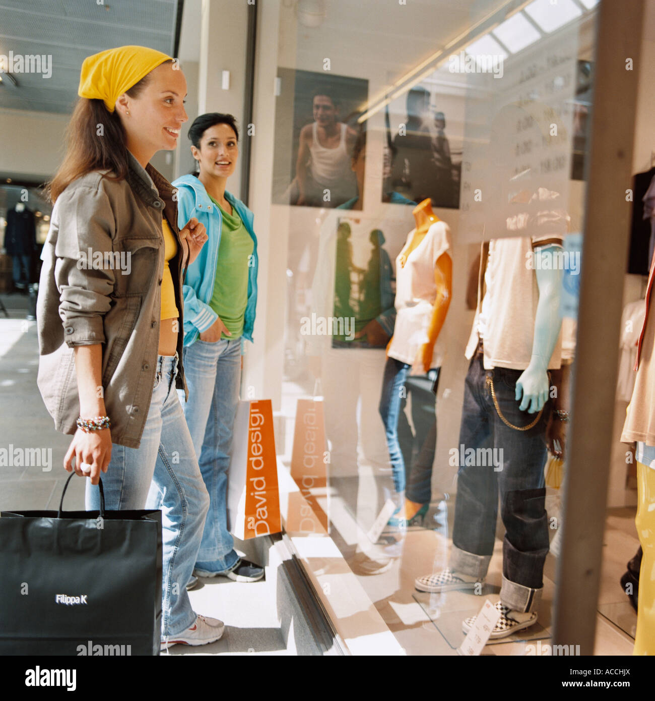 Two women looking at a shop-window Stock Photo - Alamy