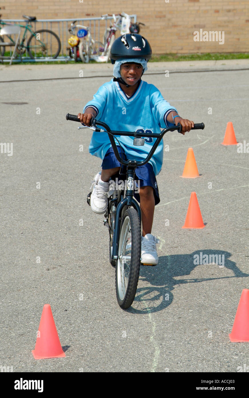 Ethnic male child with protective helmet takes safety bicycle test ...