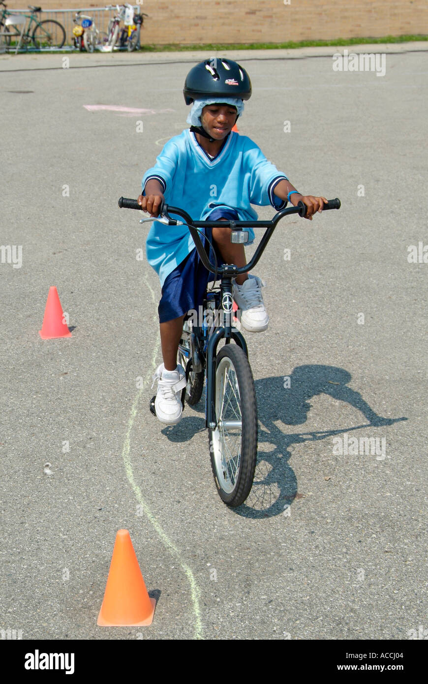 Ethnic male child with protective helmet takes safety bicycle test ...