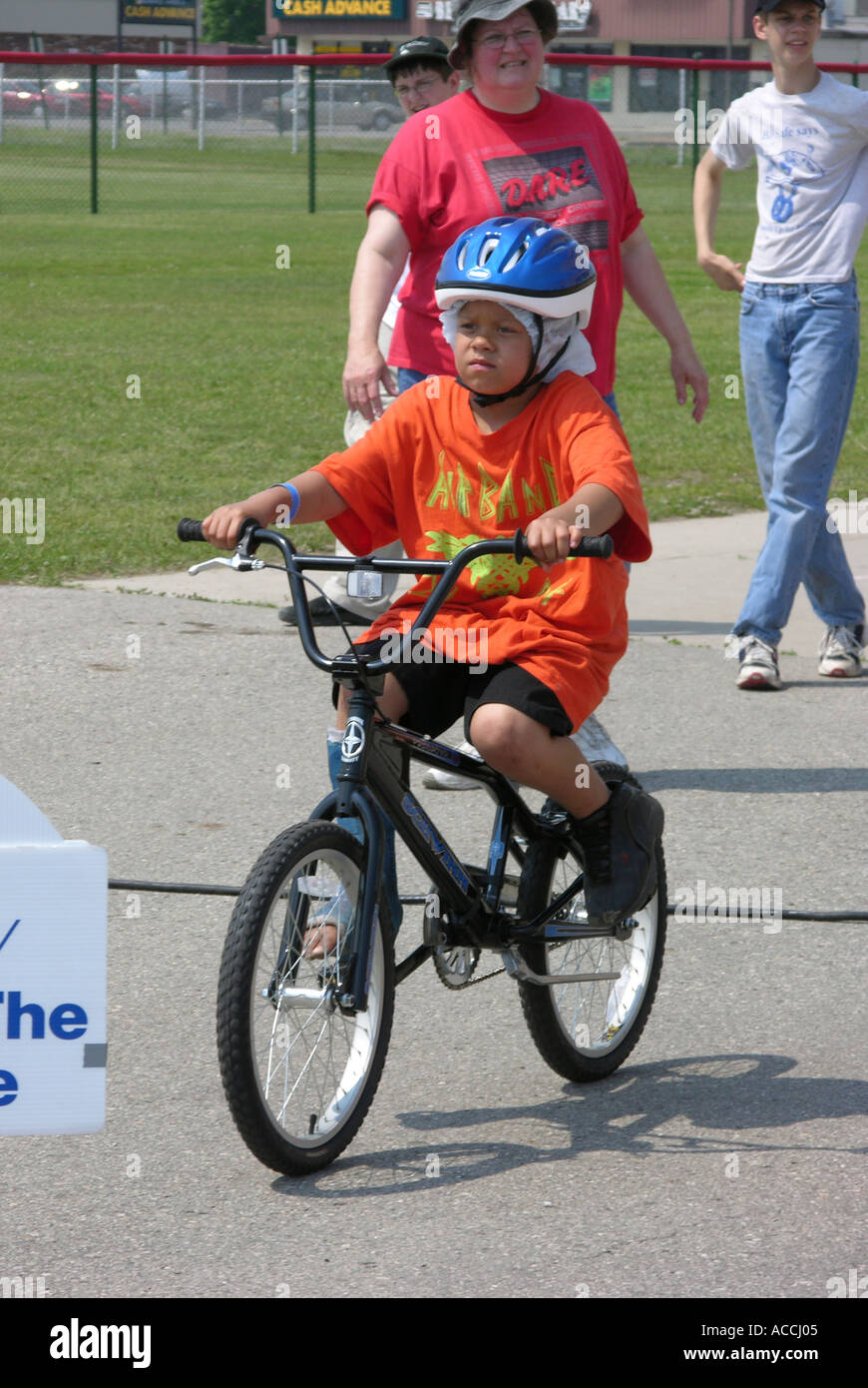 Ethnic male child with protective helmet takes safety bicycle test ...