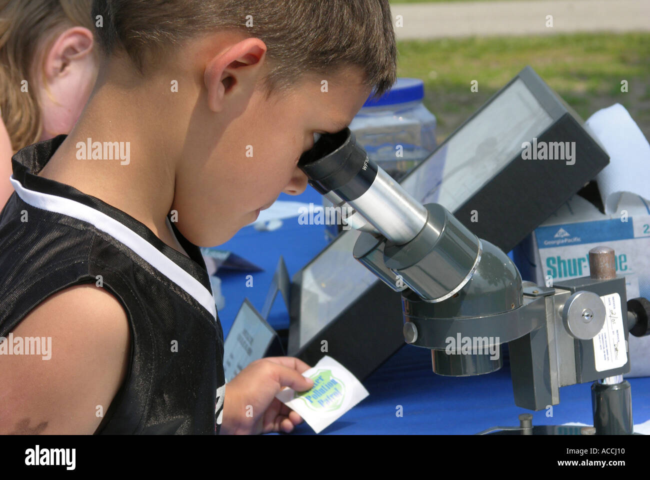 Child looks through microscope at elementary school age science fair ...