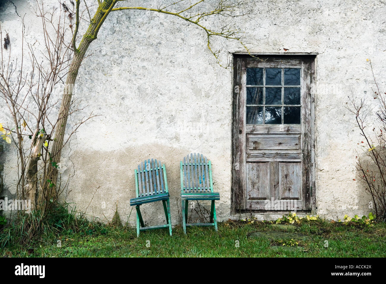 Two wooden chairs and a worn door Stock Photo - Alamy