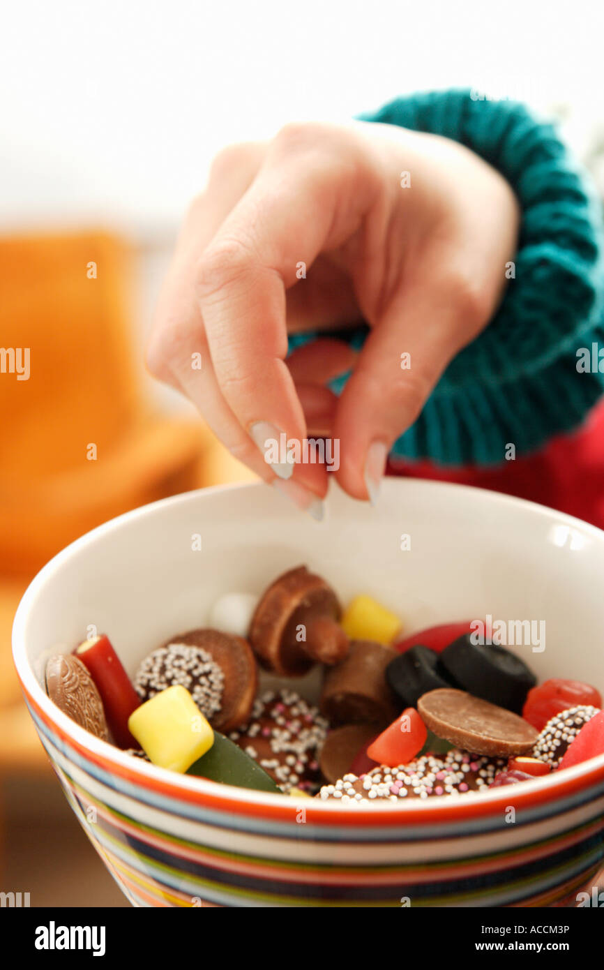 Hand and bowl with candy Stock Photo - Alamy