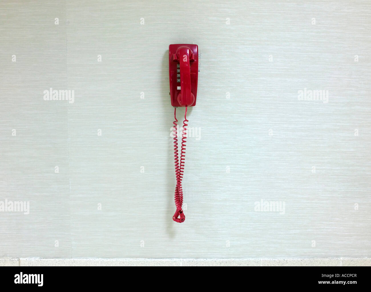 A red telephone on a white wall Stock Photo - Alamy