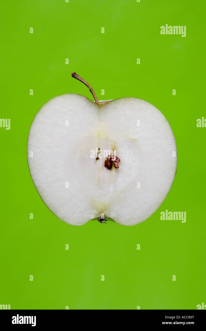 A split apple on a green background Stock Photo - Alamy