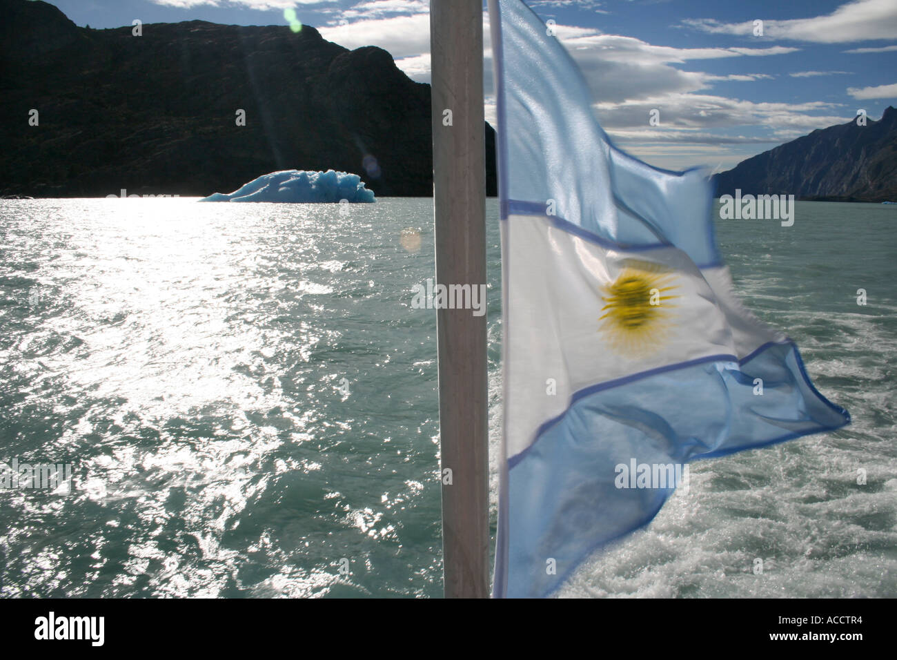Argentina blue, white and sun flag, glacier face in background ...