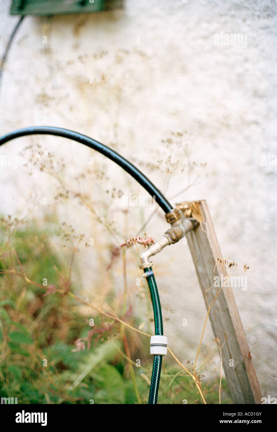 Hose connections by a house wall Stock Photo - Alamy