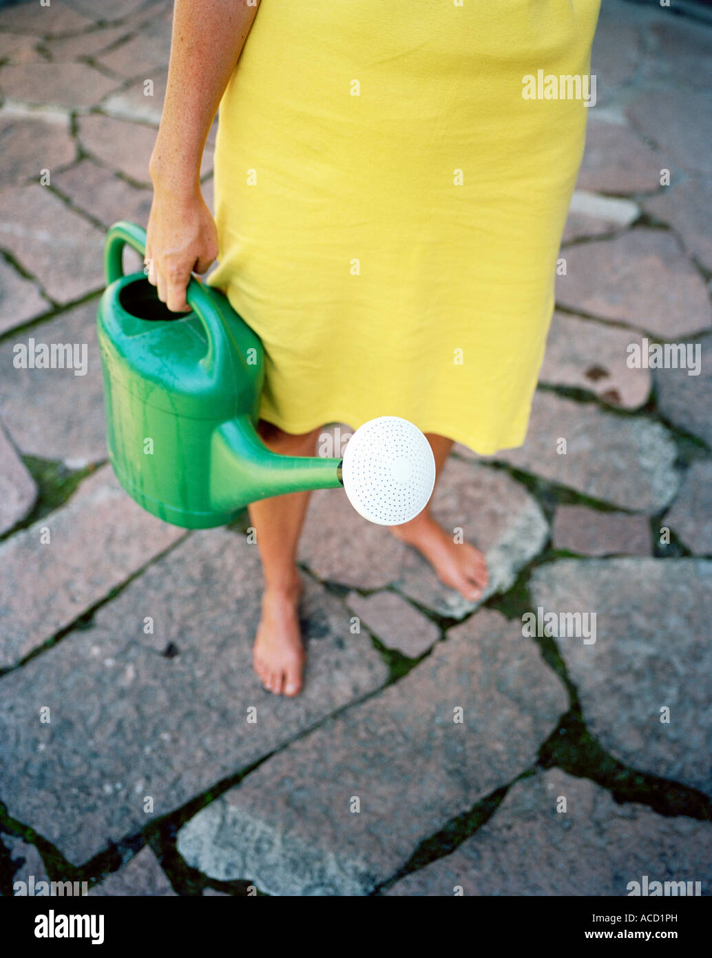 Woman carrying a watering can Stock Photo - Alamy