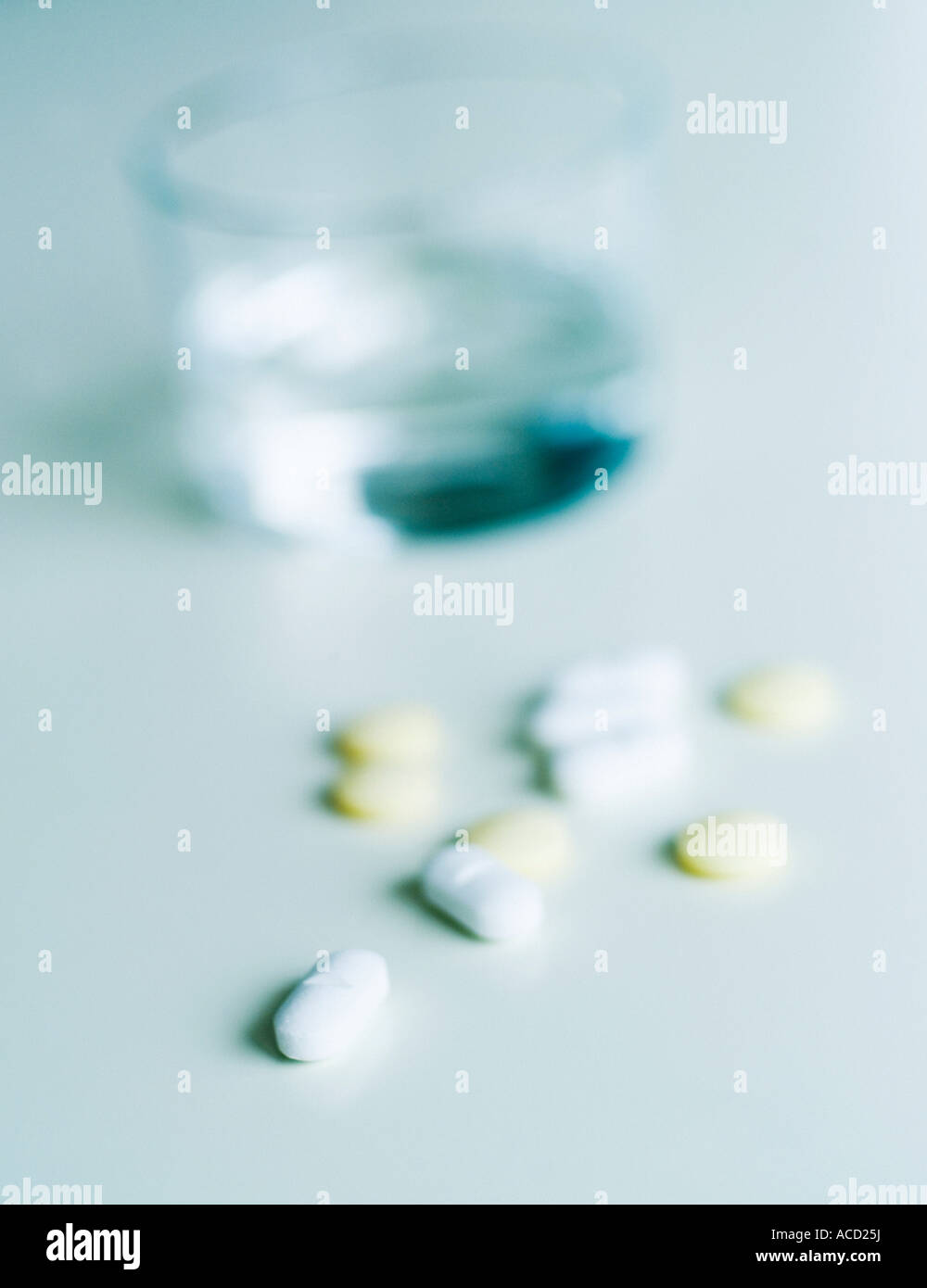 Pills by a glass of water Stock Photo - Alamy
