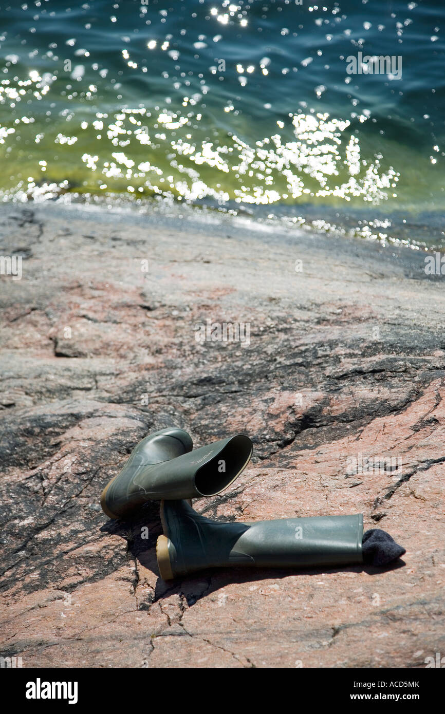 Rubber boots on a rock Stock Photo - Alamy