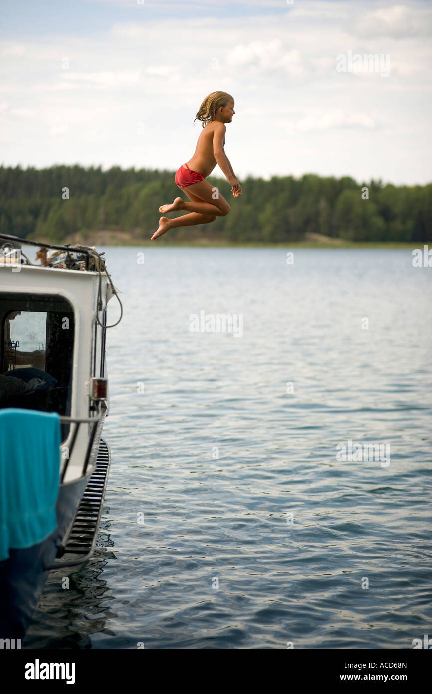 A girl jumping into the water from a boat Stock Photo - Alamy