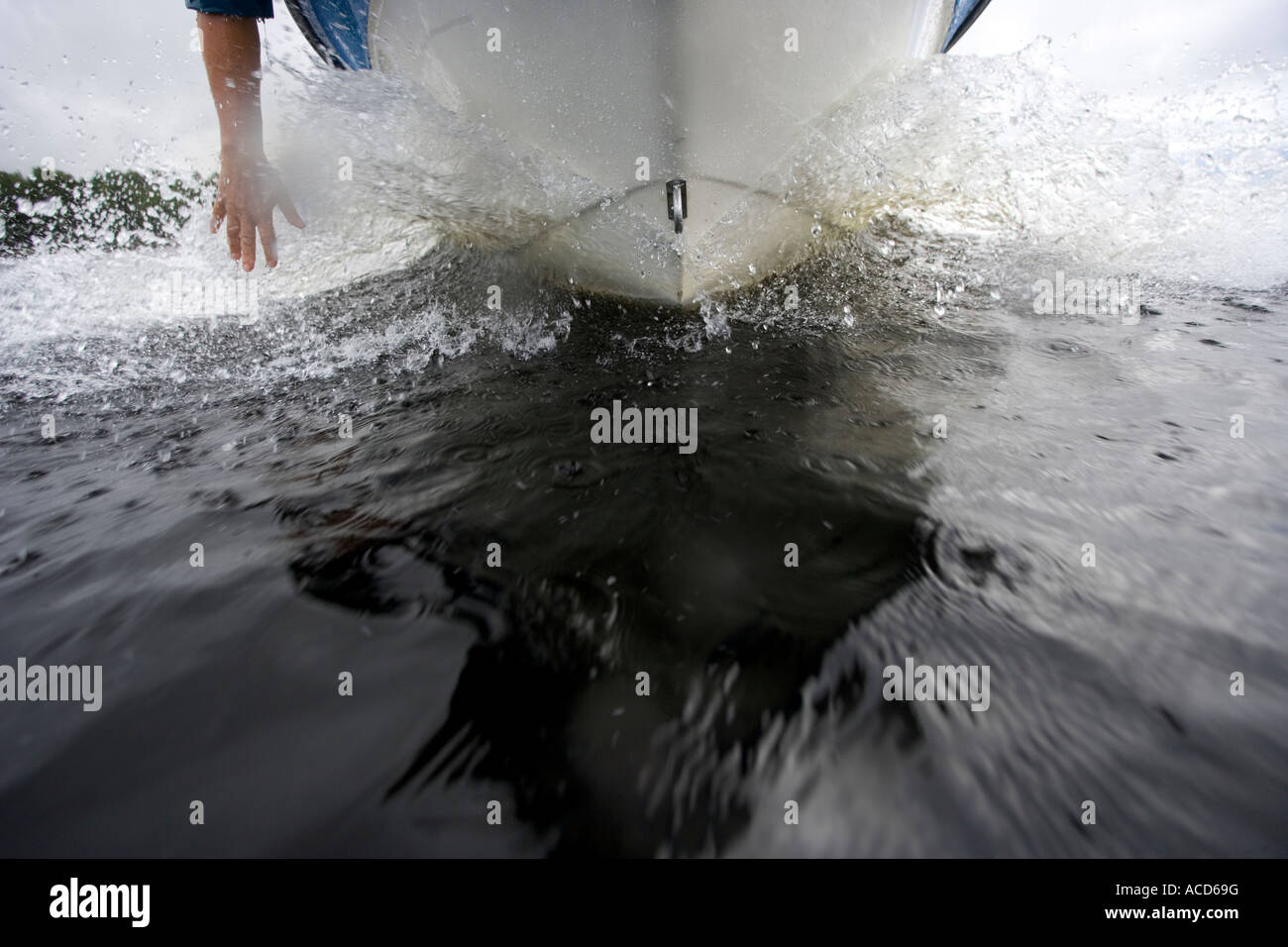 A person touching the water during a boat trip Stock Photo - Alamy