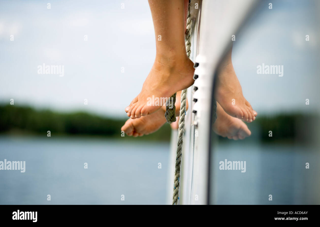 Feet on the side at a boat Stock Photo - Alamy