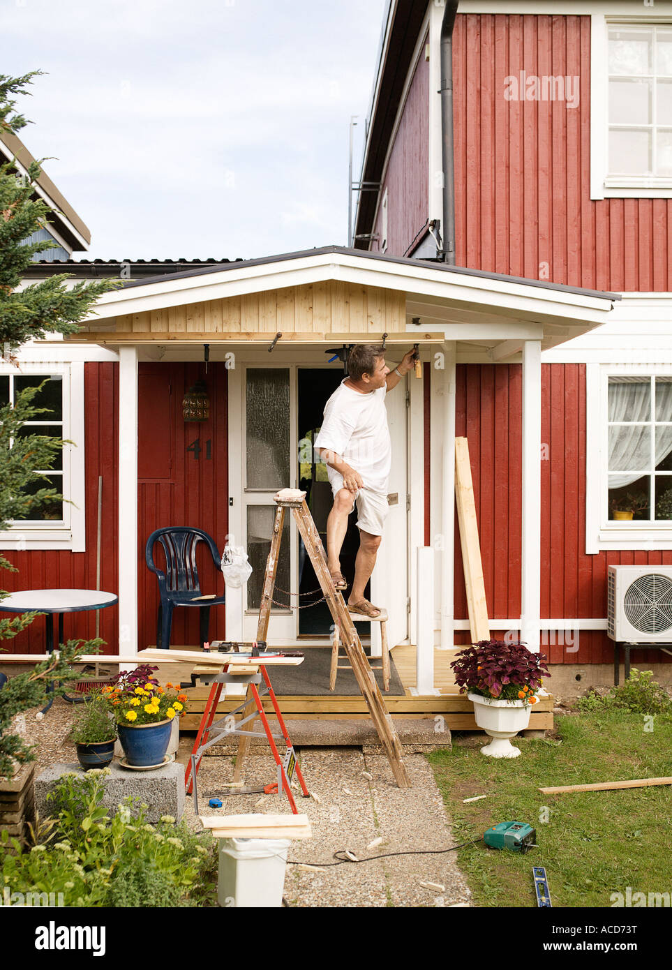 A man doing woodwork on a house Stock Photo - Alamy