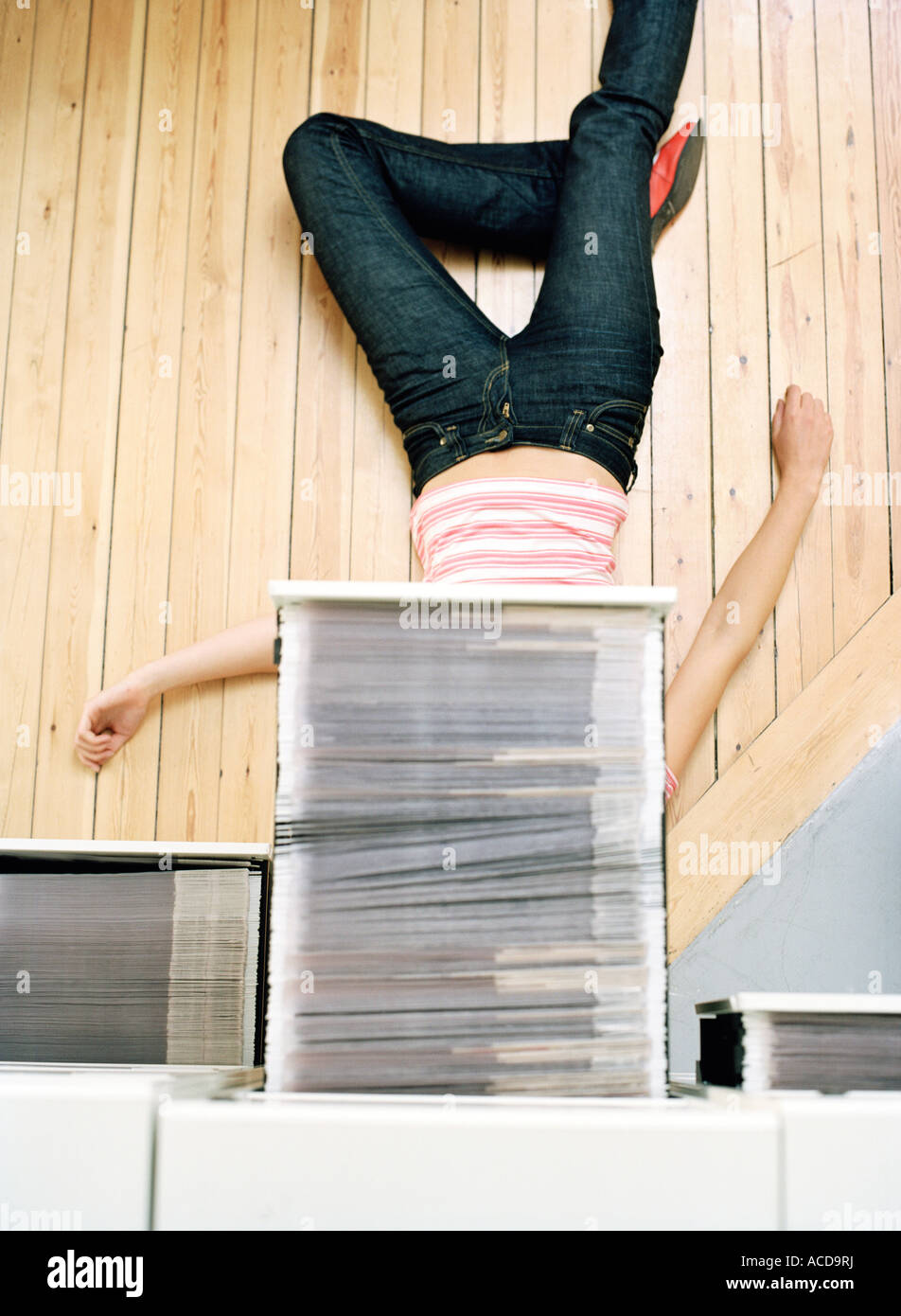 A woman lying beneath a pulled out drawer in a filing cabinet Stock ...