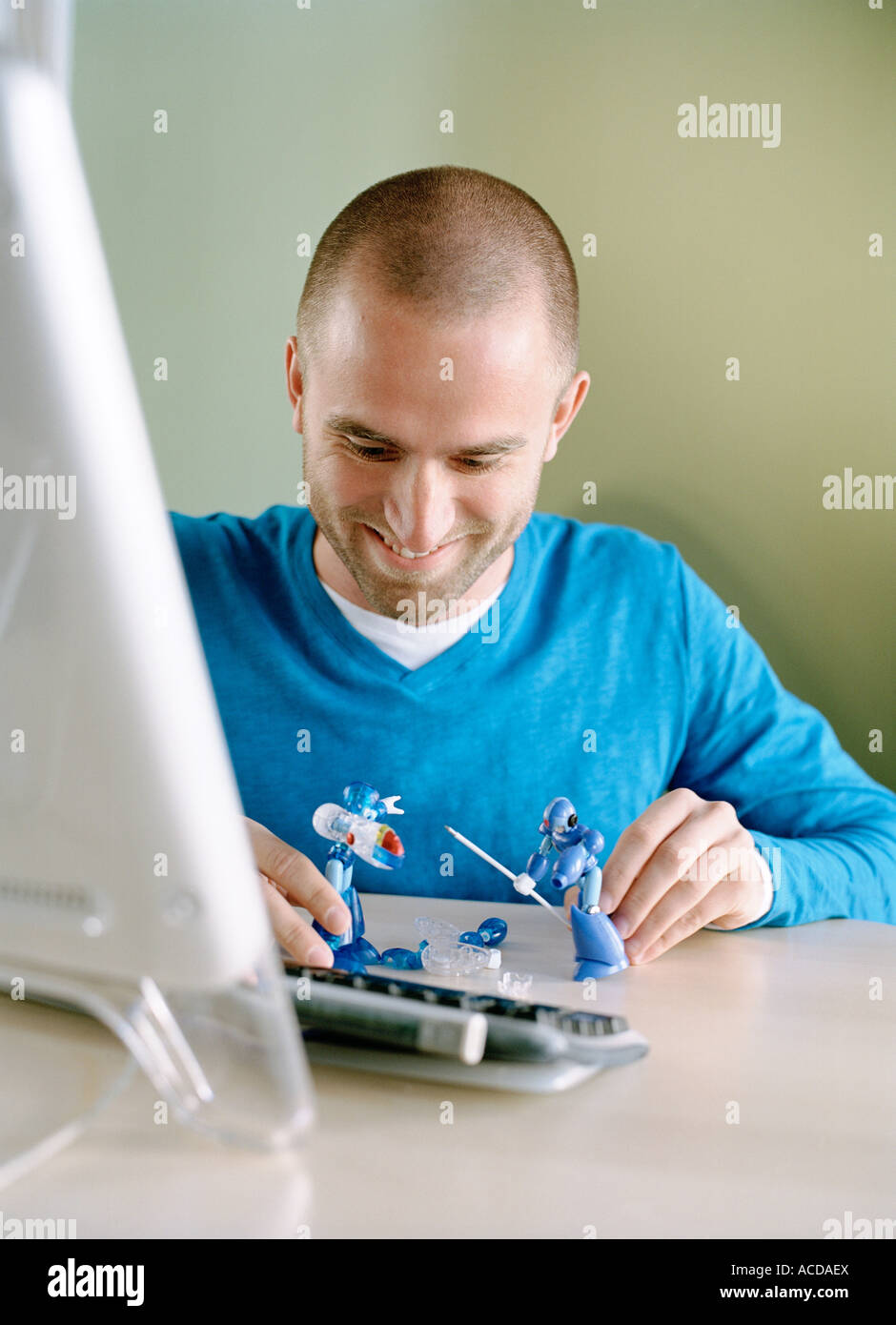 A man playing with toys on a desk Stock Photo - Alamy