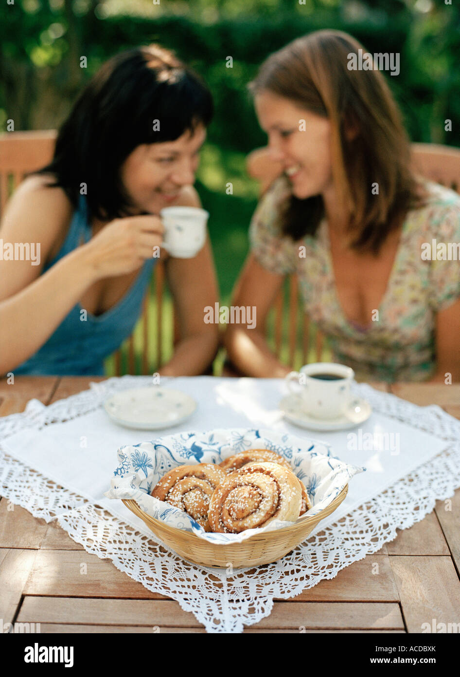 Two women having coffee outdoors Stock Photo - Alamy