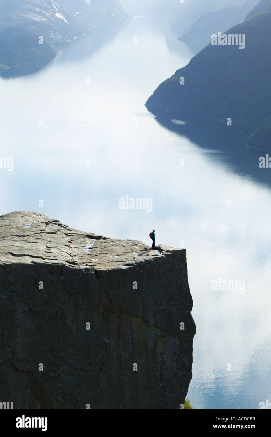 Walker standing on Preikestolen, or Pulpit Rock, above Lysefjorden ...