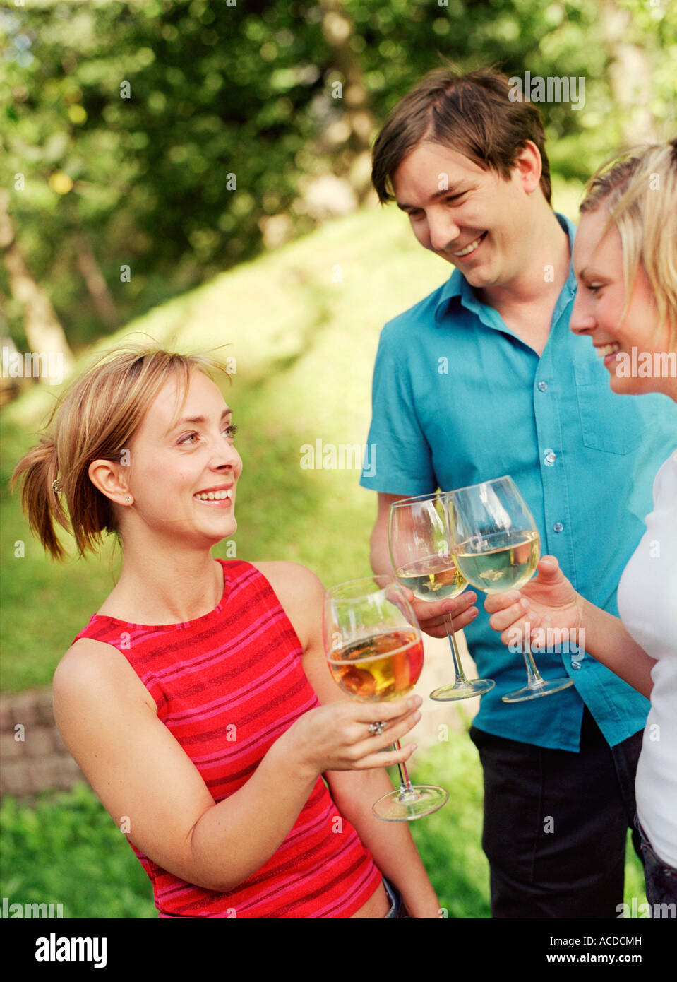 Three people toasting in a garden Stock Photo - Alamy