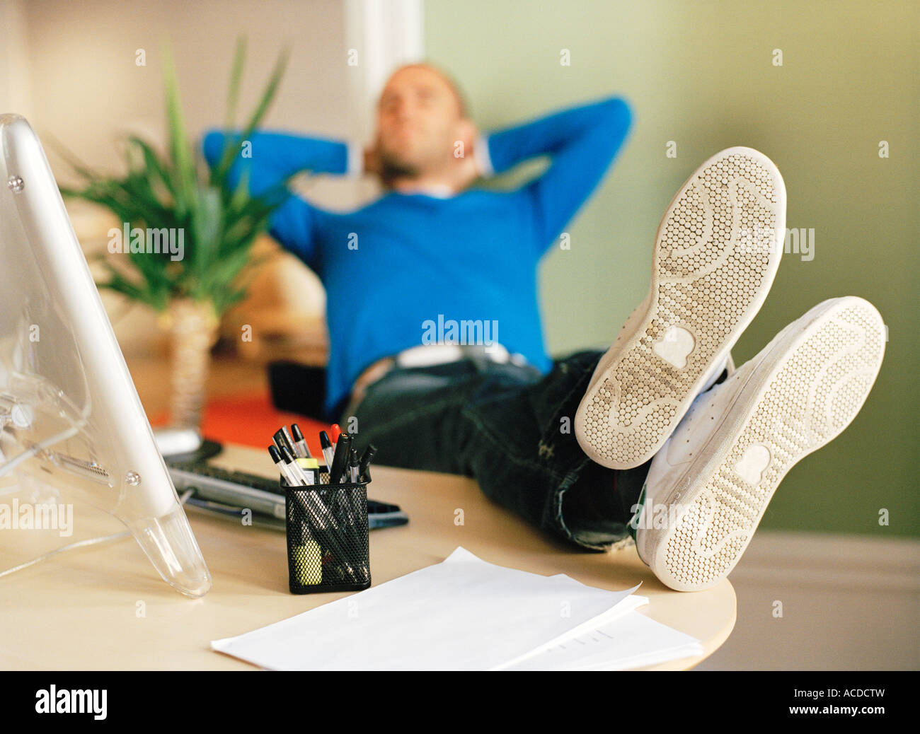 A man resting his legs on a table Stock Photo - Alamy