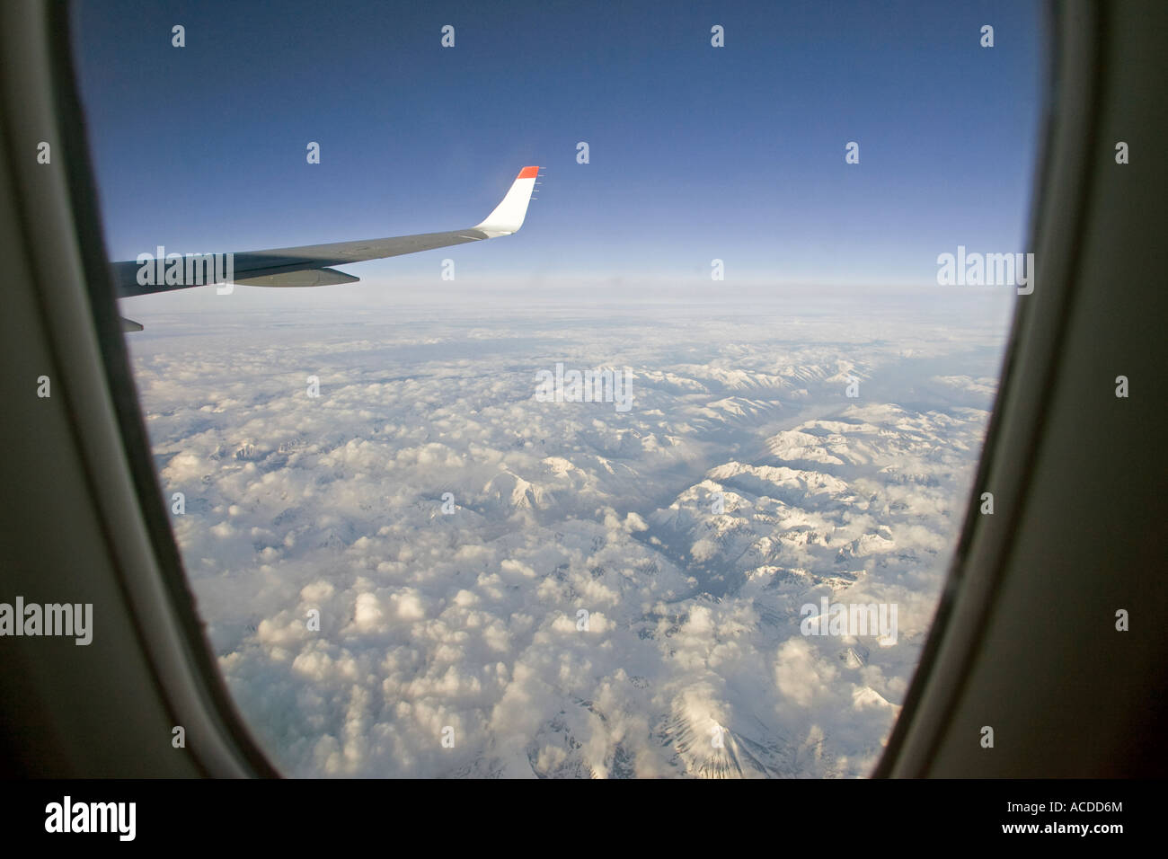 VIew of snow capped mountains from an airplane window Stock Photo - Alamy