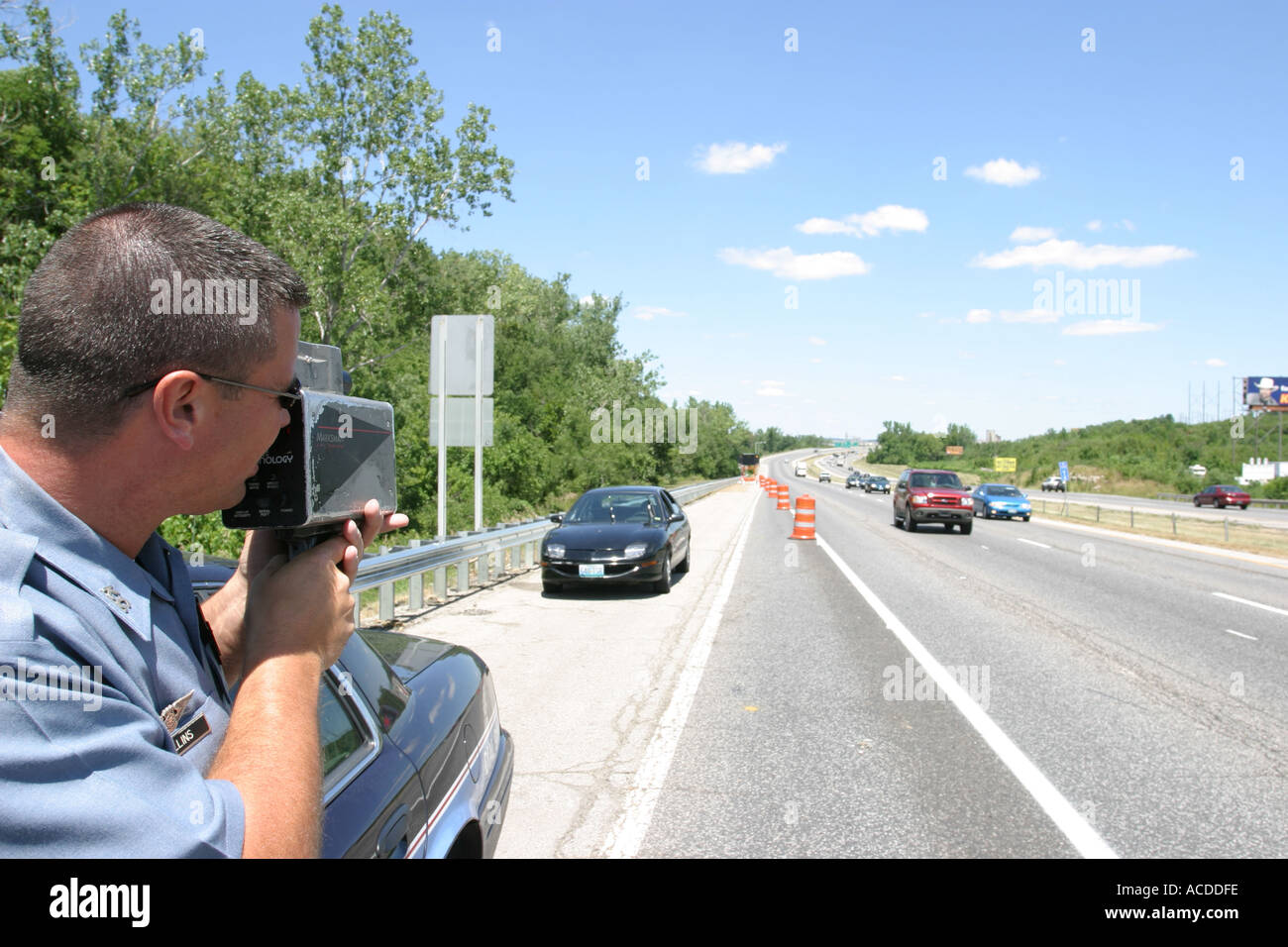 Police officer measuring speed of oncoming traffic using hand held ...