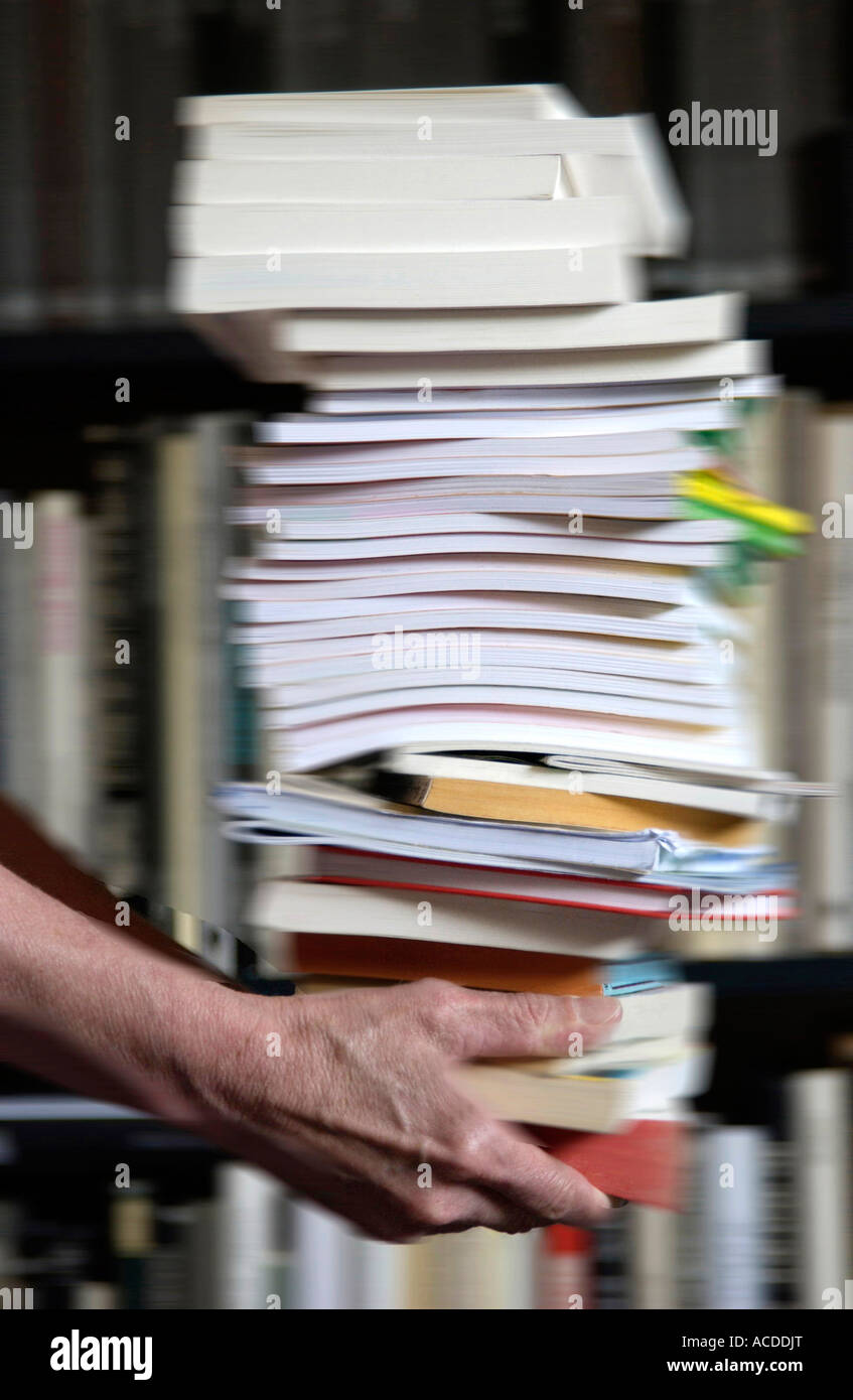Hands carrying a stack of books in a bookshop Stock Photo - Alamy